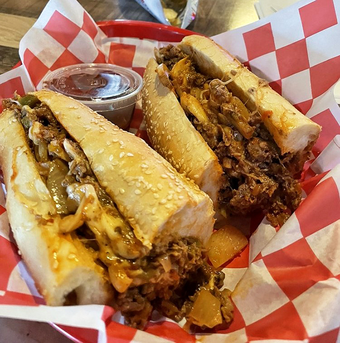 Two cheesesteaks nestled in their red-checkered basket like precious artifacts&mdash;Philadelphia's contribution to world civilization, served with a side of napkins you'll definitely need.