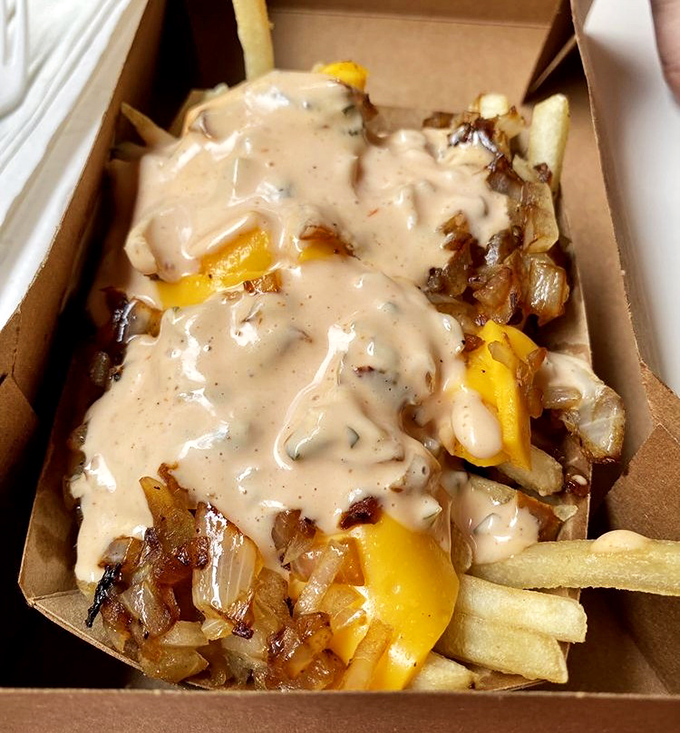 These fries, smothered in cheese sauce and grilled onions, aren't just a side dish – they're the main event that happens to come with your burger.