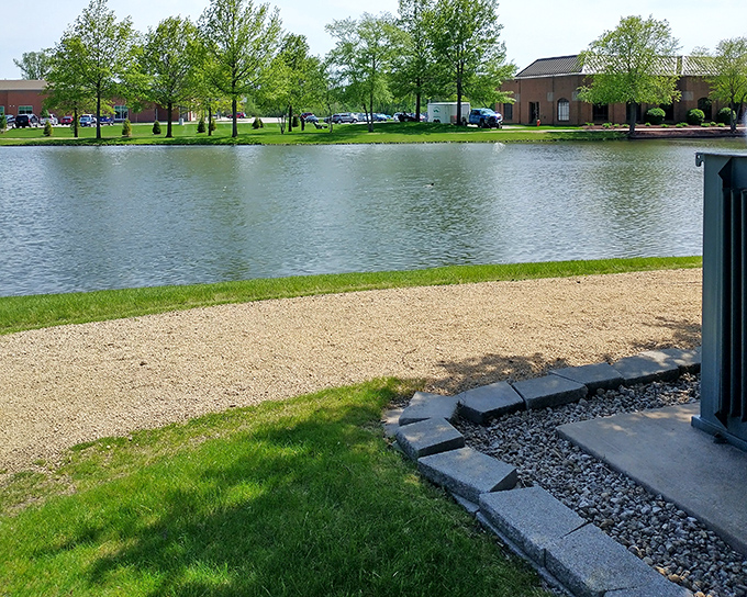 Peaceful waters reflect the surrounding greenery at this Moline pond, where urban planning embraces nature's calming influence.