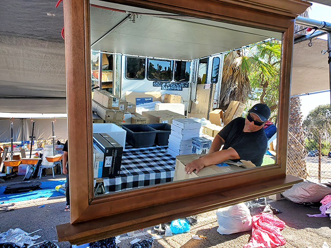 Every mirror at the swap meet tells a story&mdash;this one frames both merchandise and merchant in a perfect tableau of commerce and craftsmanship.