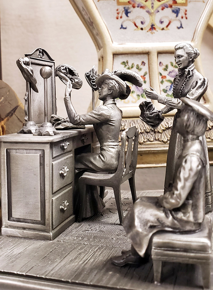 These silver figurines are frozen in Victorian elegance, silently judging your modern fashion choices while elevating your mantelpiece game.