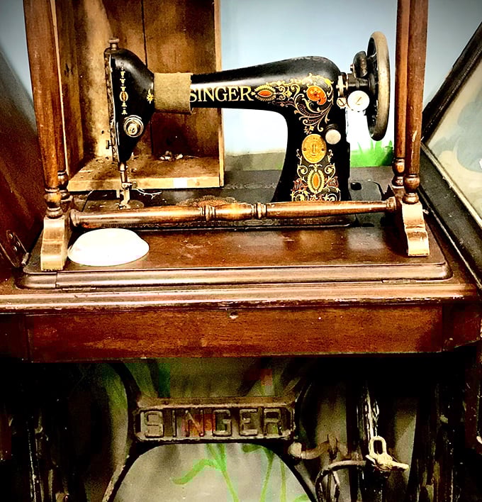 This ornate Singer sewing machine once stitched together family wardrobes and wedding dresses, its wooden cabinet as beautiful as the garments it created.