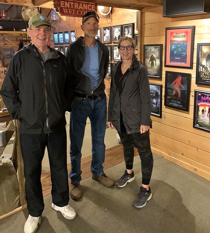 Visitors examine the extensive collection of Bigfoot memorabilia and evidence. The wood-paneled walls practically whisper tales of mysterious forest encounters.