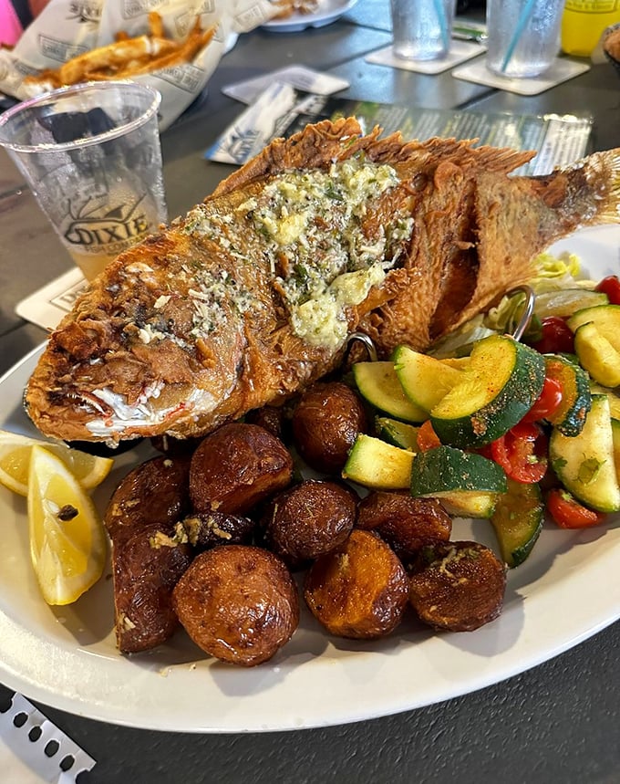 The whole fried fish looks like it's auditioning for a food magazine cover. Those roasted potatoes deserve their own fan club.
