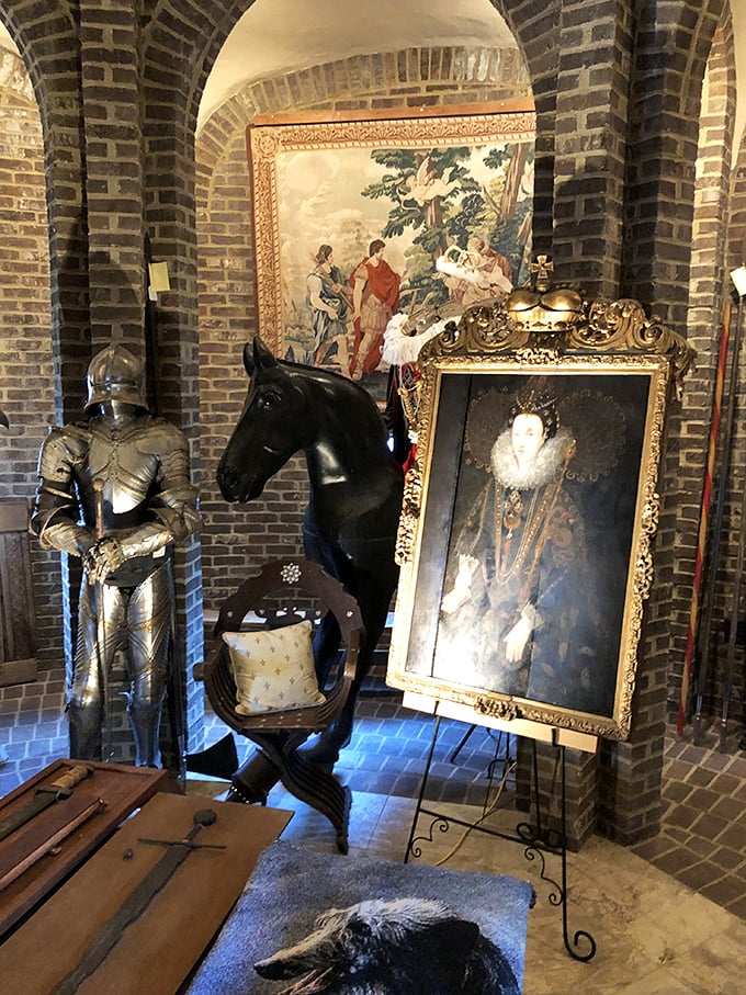 Art and armor create a perfect medieval tableau. This corner of Castle Gwynn showcases period portraiture alongside knightly accoutrements, blending history with artistic appreciation. 