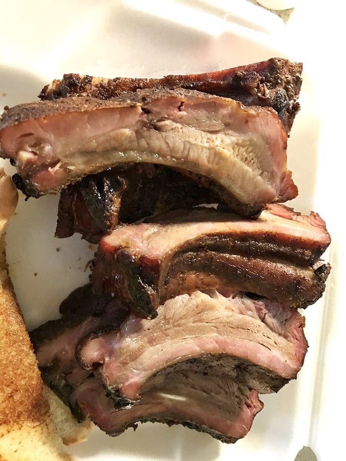 These ribs have the kind of smoke ring that would make Saturn jealous. Each bite is a reminder of why opposable thumbs were evolution's greatest gift.