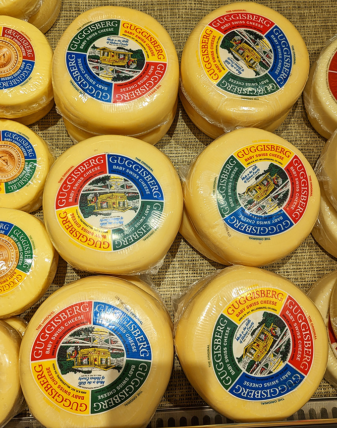 Baby Swiss wheels with their colorful labels stand ready for adoption. Those distinctive little eyes aren't just holes&mdash;they're windows to flavor paradise.