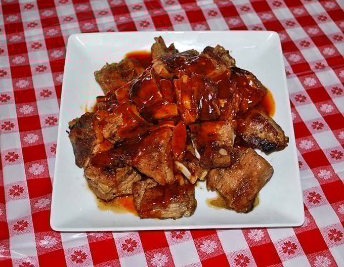 Ribs glistening with sauce that should have their own ZIP code. The kind worth wearing a bib for.