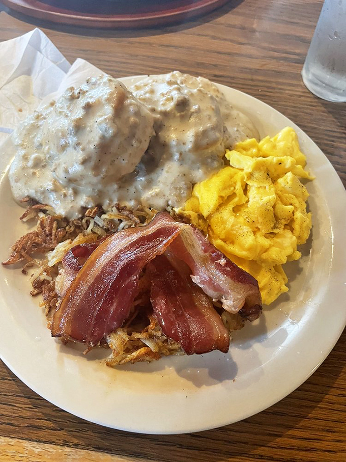Biscuits swimming in gravy with bacon standing guard &ndash; this plate doesn't just break your fast, it demolishes it with Southern charm.