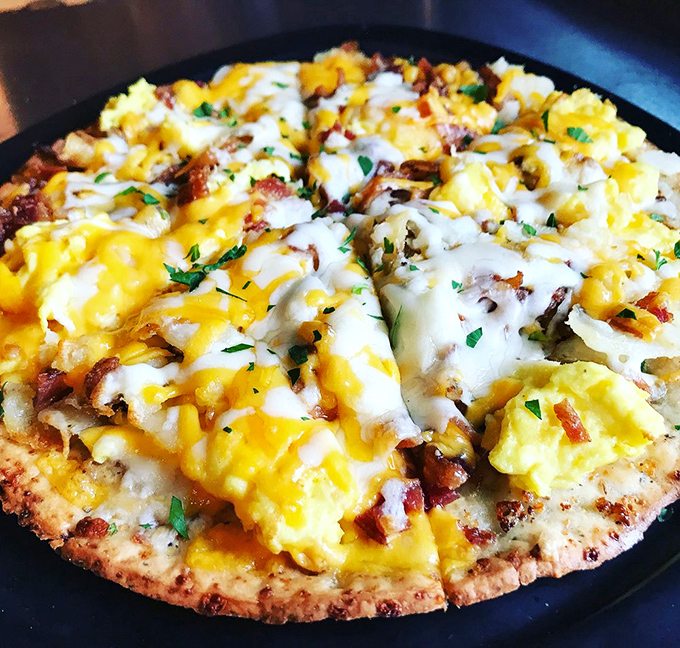 Breakfast pizza: the innovation nobody asked for but everyone secretly needed. Eggs, cheese, and bacon on a crispy crust.
