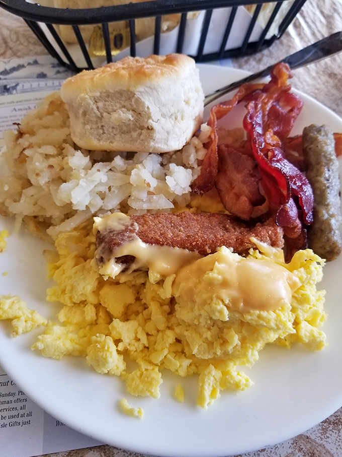Breakfast perfection: golden eggs, bacon with the ideal crisp-to-chew ratio, and a biscuit so fluffy it might float away without that sausage gravy anchor.