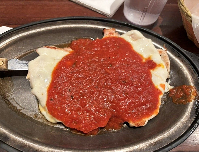 The legendary chicken parmesan that blankets tender meat in rich marinara sauce and melted cheese perfection.