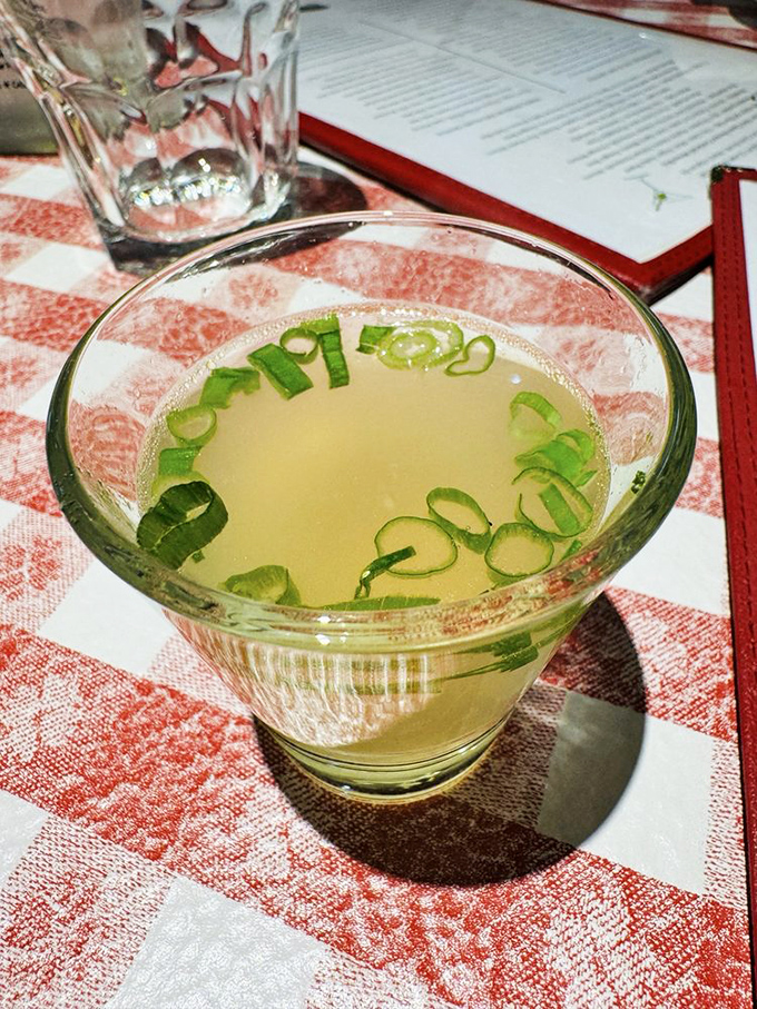 The ritual begins with this&mdash;warm clam juice garnished with green onions, a briny welcome shot that separates tourists from devoted regulars.