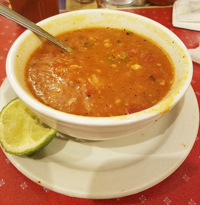 A bowl of conch chowder with a lime wedge standing by. Florida in liquid form, ready to warm your soul.