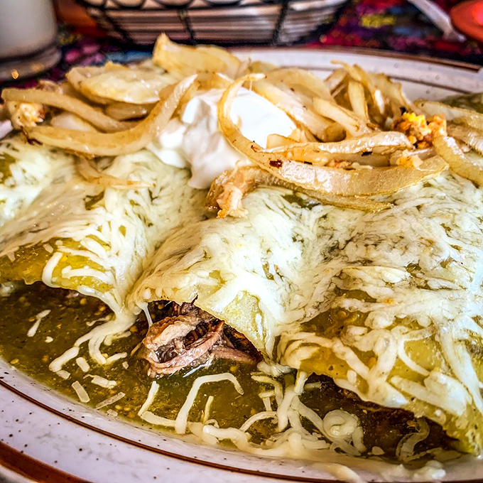 These enchiladas swim in a verdant sea of tomatillo sauce, topped with melted cheese and crispy onions. Your fork doesn't stand a chance.