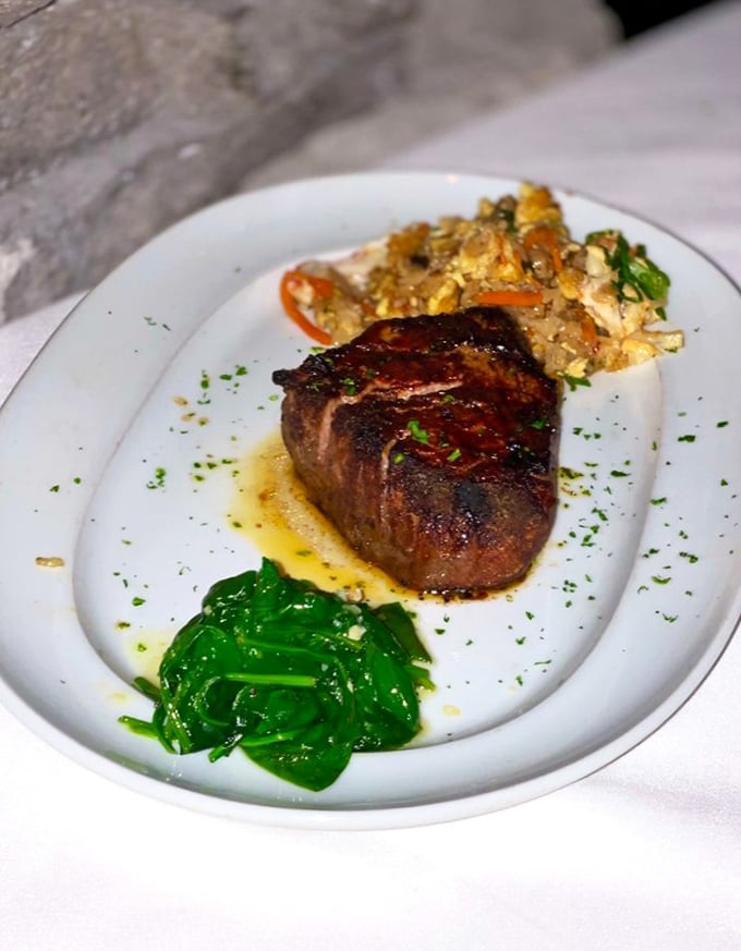 A perfectly cooked filet mignon flanked by vibrant sides—proof that vegetables can still make the A-list at a steakhouse if they bring their A-game.