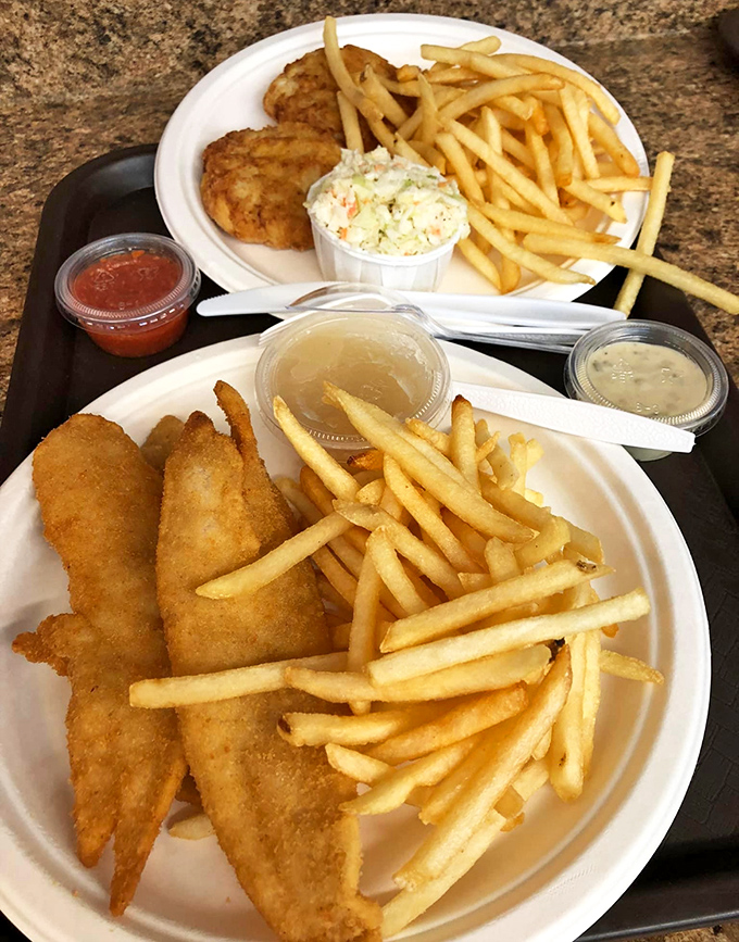 Two plates of seafood perfection&mdash;golden fish, crispy fries, and that essential cup of coleslaw. Comfort food that would make Poseidon himself come ashore for dinner.