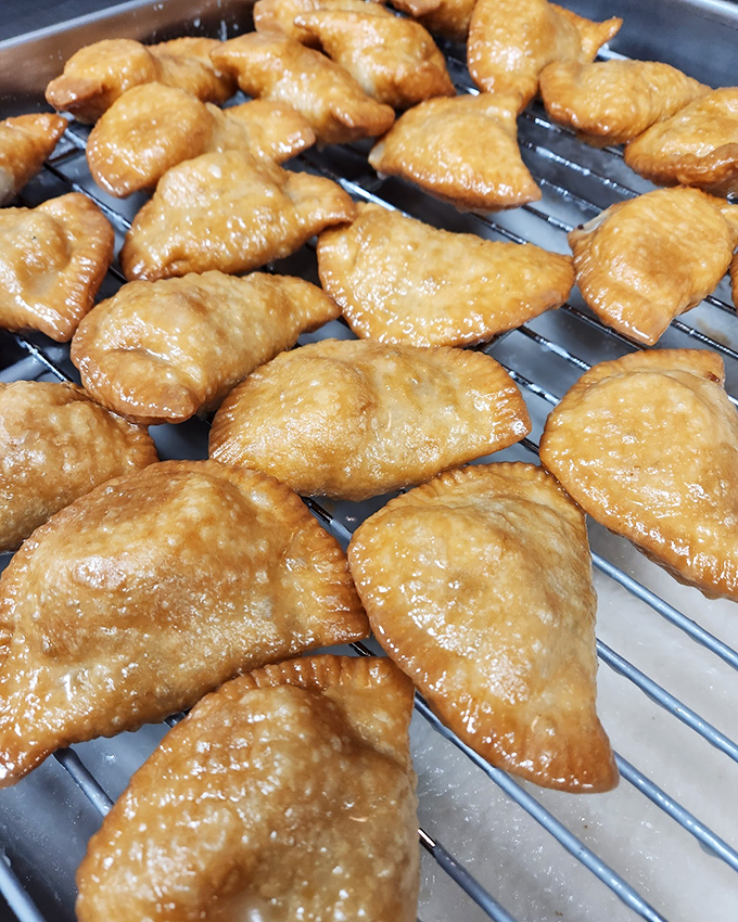 Golden fry pies cooling on the rack&mdash;crisp, glistening pastry pockets waiting to deliver their sweet filling straight to your happiness center.