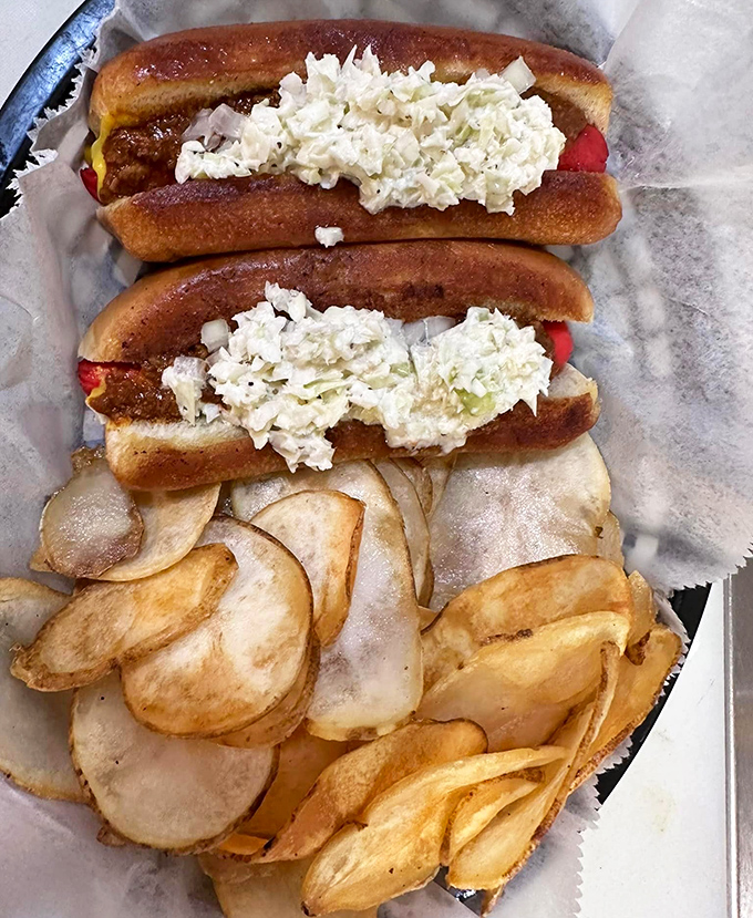 Hot dogs elevated to an art form, topped with creamy slaw and served alongside homemade chips that crackle with each delicious bite.