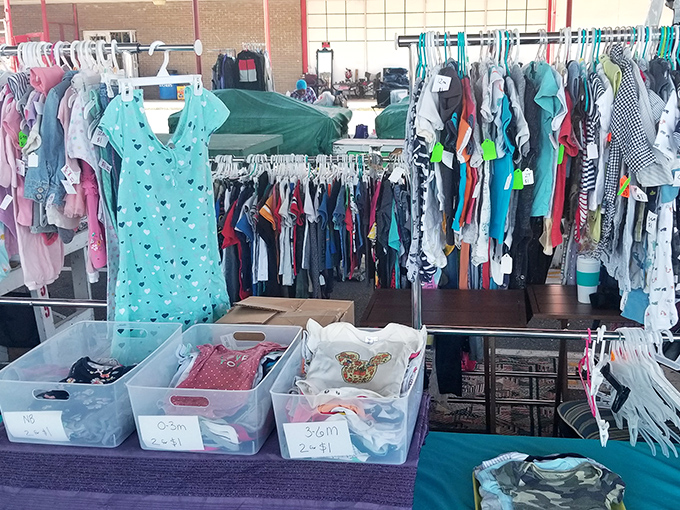 Childhood memories hang on metal racks. These tiny garments represent big savings for growing families with shrinking budgets.