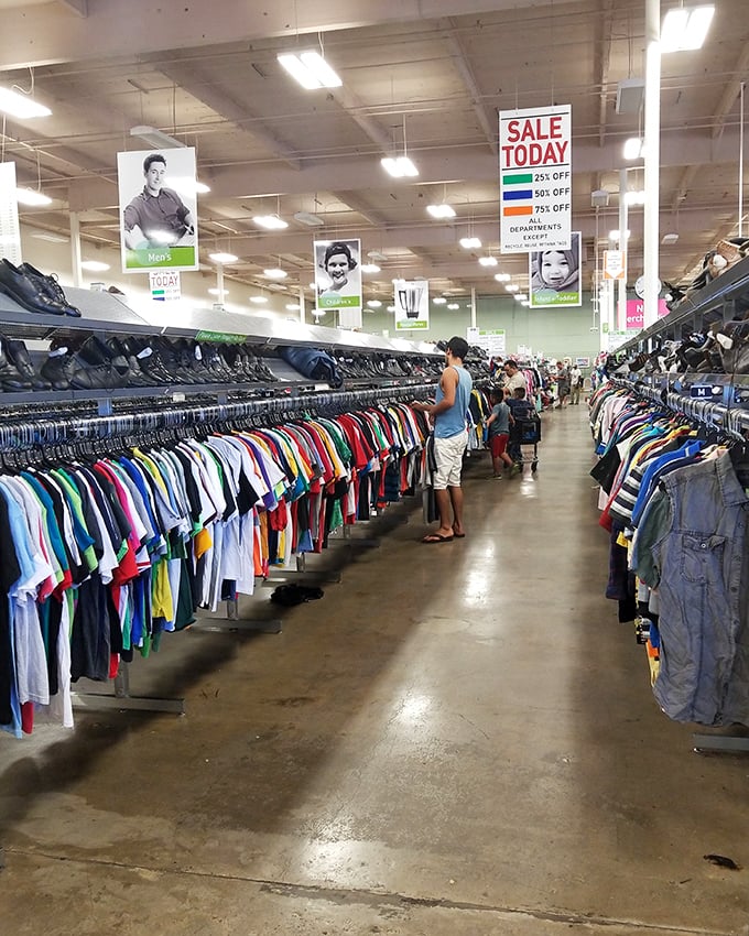 The men's department: where shoppers hunt for hidden gems while signs overhead promise discounts that'll make your wallet smile.