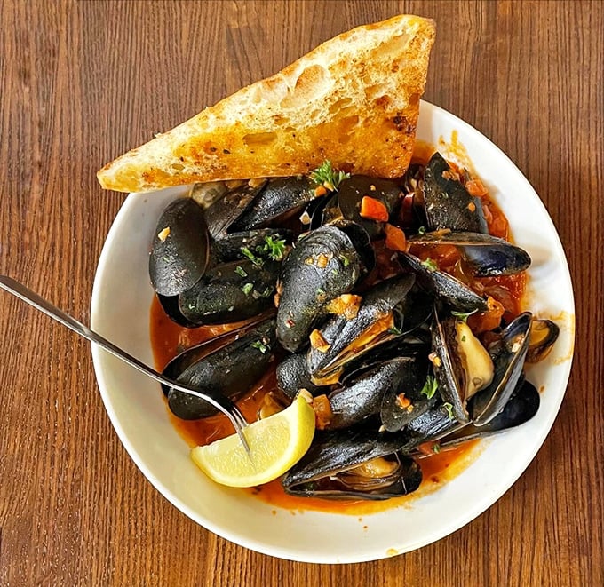 Mussels swimming in a savory broth with a side of crusty bread&mdash;nature's perfect dipping mechanism for oceanic treasure hunting.