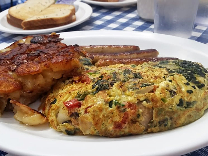 Whoever said "you can't improve perfection" never met this veggie-packed omelet&mdash;a golden parcel of morning joy with crispy potatoes and sausage links standing guard.