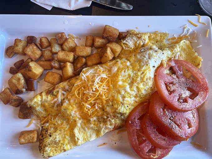 The star of the show: a perfectly executed omelet with crispy potatoes and fresh tomatoes. Breakfast architecture at its finest.