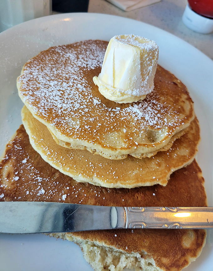 Pancakes stacked higher than Florida's humidity, crowned with a melting butter hat and powdered sugar snowfall. Your diet plan just called&mdash;it's taking the day off.