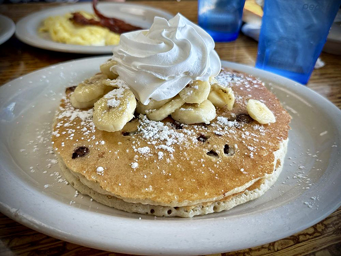 Pancake perfection topped with bananas, whipped cream, and what appears to be chocolate chips. Breakfast or dessert? The line deliciously blurs.