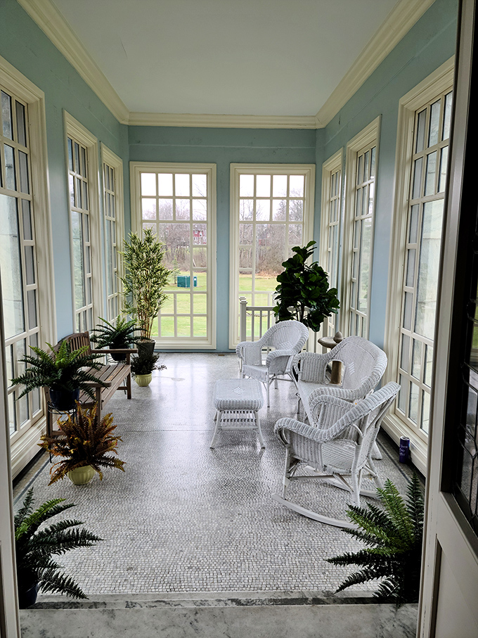 The sunroom's wicker furniture and wall-to-wall windows create the perfect spot for morning coffee or plotting your next industrial empire&mdash;your choice. 
