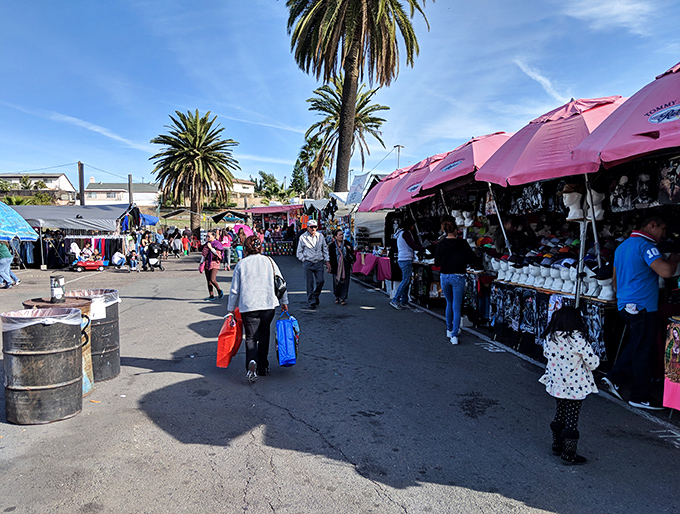The swap meet runway, where shoppers parade their finds under a canopy of pink umbrellas and California's endless blue sky.