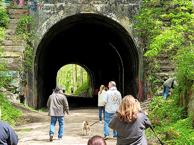 Explorers of all ages venture through the tunnel, some perhaps hoping for—or dreading—an encounter with Moonville's legendary spirits.