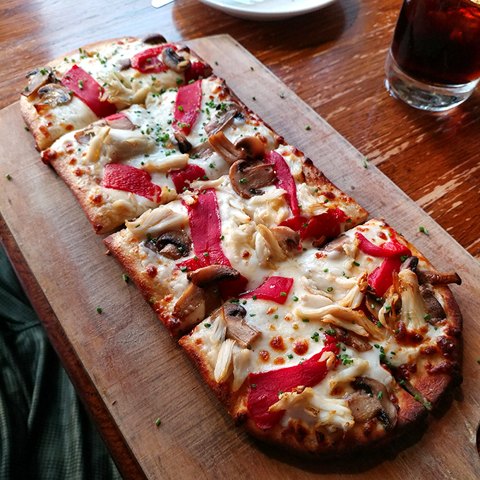 Pizza that defies categorization&mdash;thin crust, melty cheese, and toppings arranged with artistic precision. The kind worth driving across state lines for.