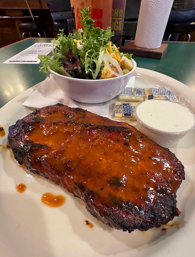 This isn't just a pork steak; it's a masterclass in smoke and fire, served with a side salad that's clearly just there for moral support.