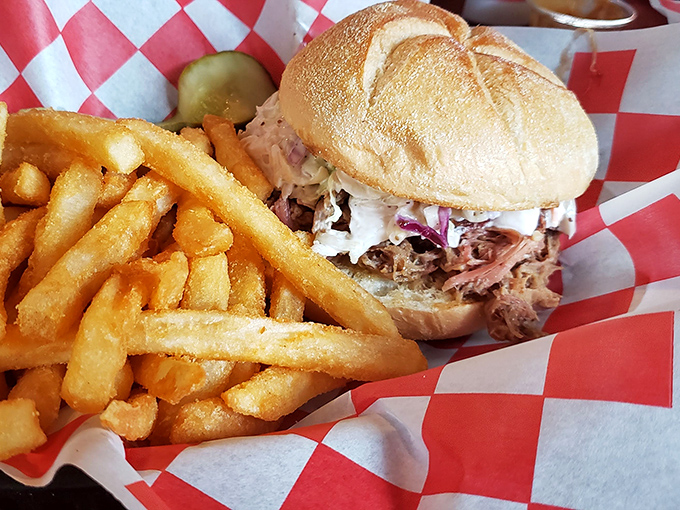 The pulled pork sandwich: a masterclass in textural contrast where smoky meat meets creamy slaw on a bun that somehow contains the delicious chaos.
