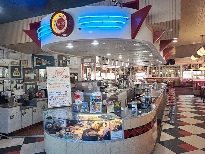 The counter where dreams and calories coexist beautifully, beneath a canopy of blue neon that bathes everything in a nostalgic glow.