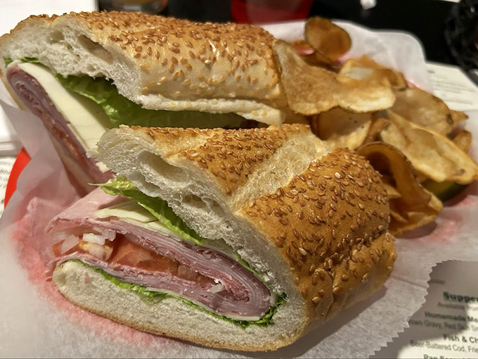 The perfect sandwich cross-section reveals layers of thinly-sliced meat, fresh vegetables, and bread with that ideal balance of softness and structure.