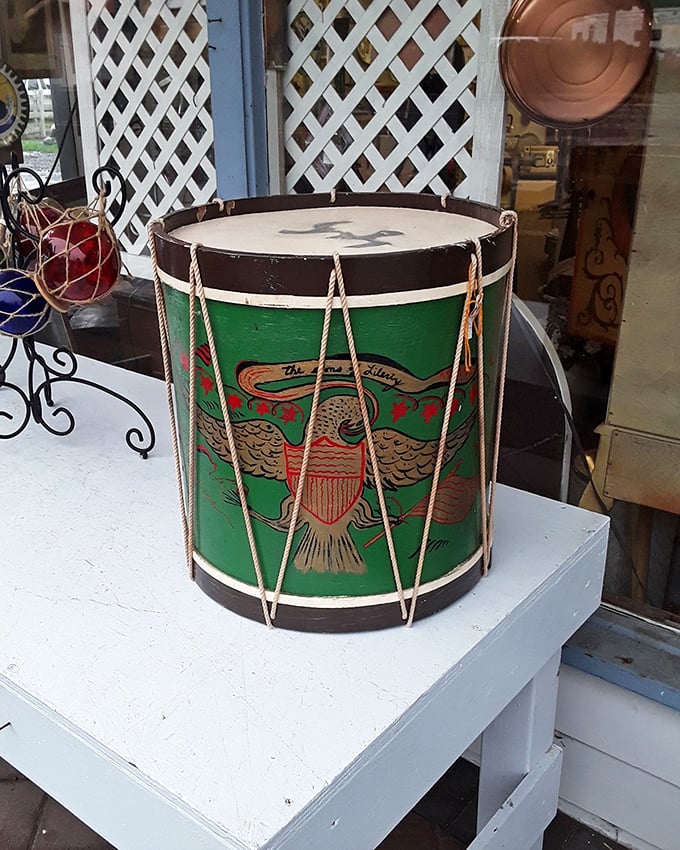 This vintage military-style drum isn't just an instrument; it's a piece of Americana that marched through history before landing on this coastal display table.
