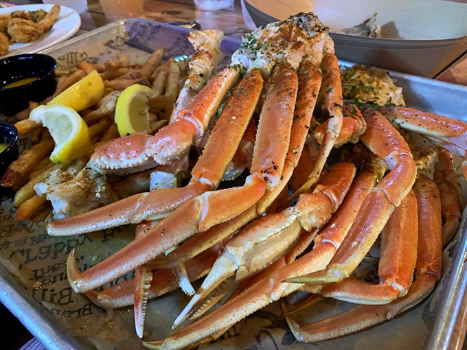 Snow crab legs arranged like nature's most delicious Jenga game. The melted butter is basically liquid sunshine in a dipping cup.