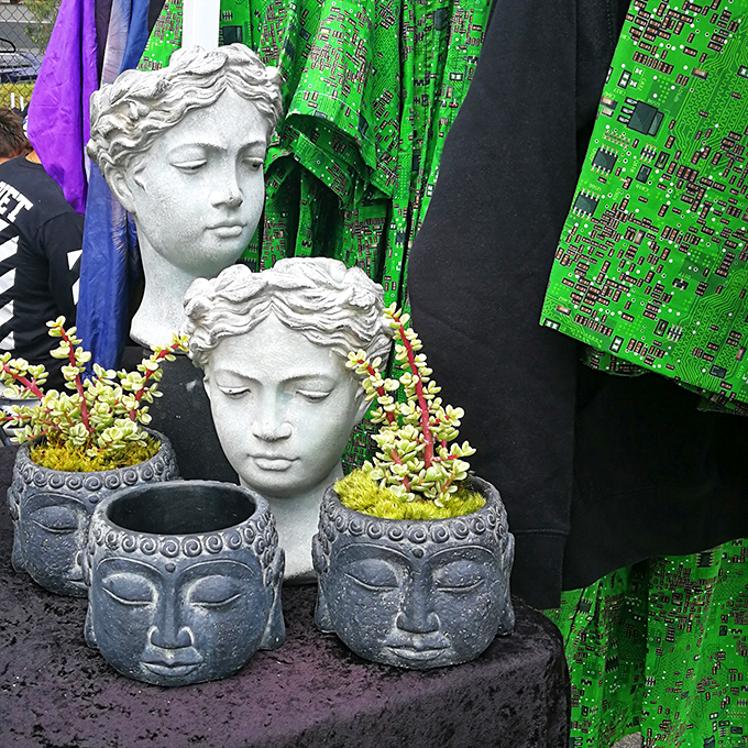 Classical statue heads meet Buddha planters in an eclectic display of decorative garden artistry. 