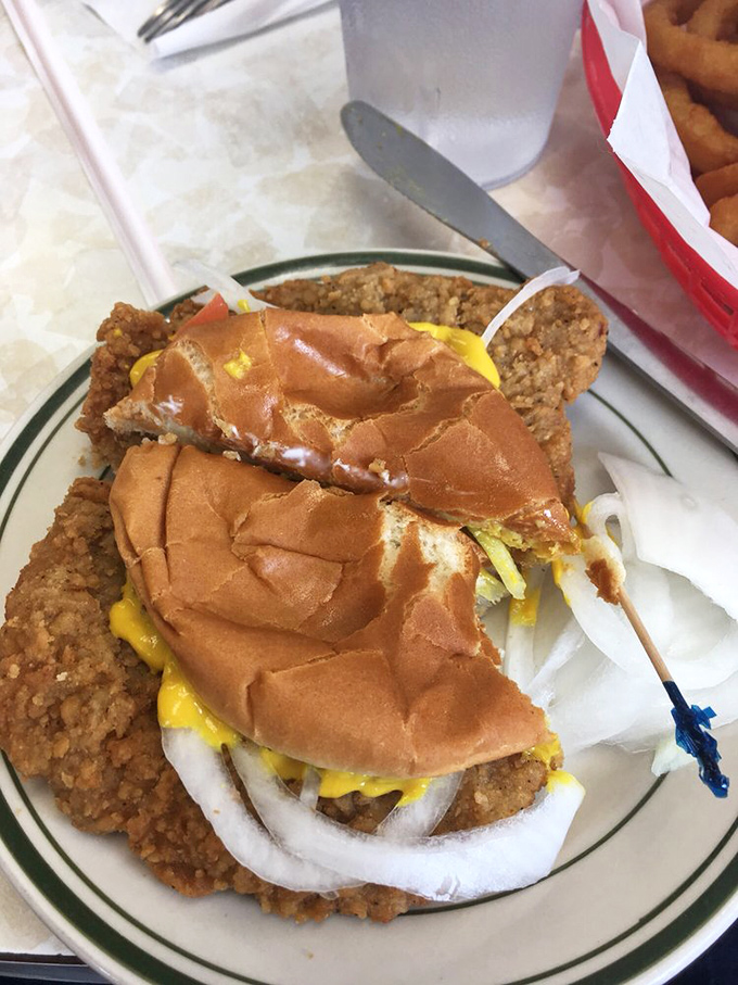 This isn't just a tenderloin sandwich; it's an engineering marvel where crispy breading meets tender pork in perfect harmony on a sadly overwhelmed bun.