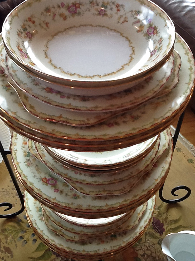 Delicate floral china stacked with precision – these gold-rimmed beauties once graced someone's special occasions and now await yours.