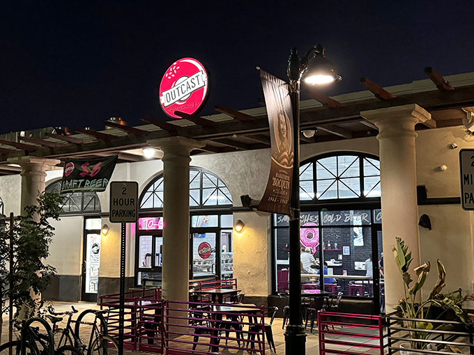 Outcast Doughnuts after dark &ndash; where night owls and sweet tooths unite under the glow of that perfect pink sign.