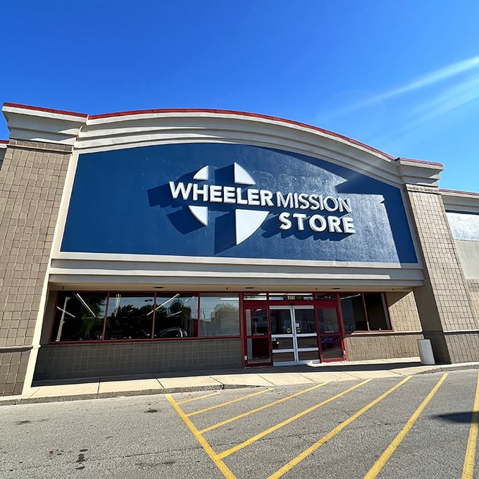 Wheeler Mission Store's distinctive curved facade stands out like a retail smile. The blue signage promises both bargains and community support.