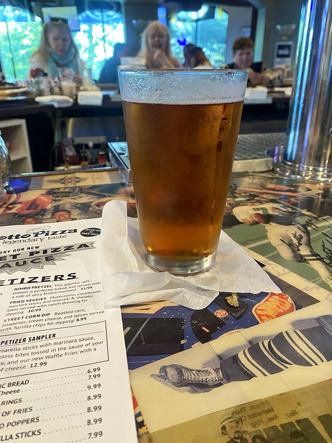 A perfectly poured beer awaits its destiny—to wash down whatever delicious decision you've just made from that tempting menu.