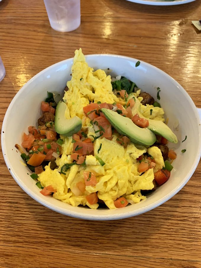 A breakfast bowl that proves vegetables can party before noon—scrambled eggs playing host to avocado, tomatoes, and greens in a morning fiesta.