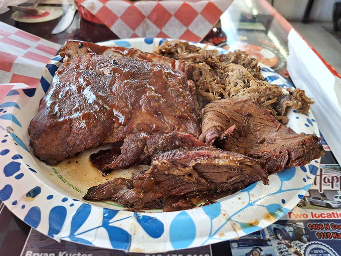 The carnivore's dream team: brisket, ribs, and pulled pork sharing a plate like old friends at a reunion. This isn't just BBQ&mdash;it's edible artwork. 