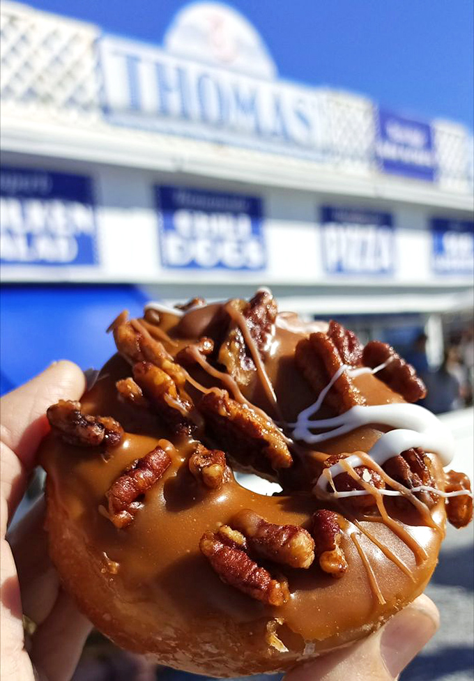 A caramel pecan donut that looks like it was designed by someone who thought, "What if we made a regular donut wear a crown?"