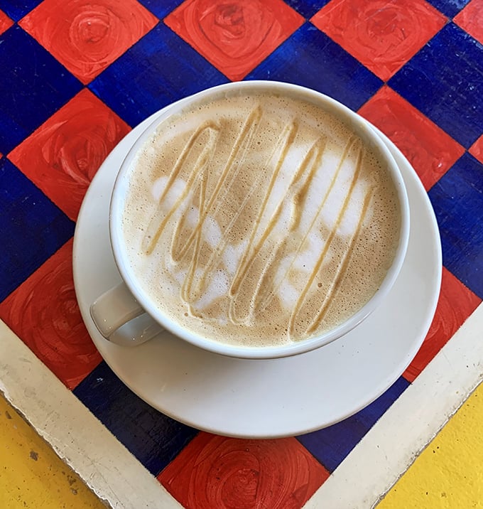 Caramel cappuccino art on a checkerboard table &ndash; when your coffee is pretty enough to photograph but too delicious to wait for the perfect lighting.